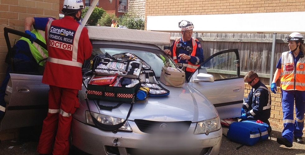 Man trapped between car and brick wall - CareFlight